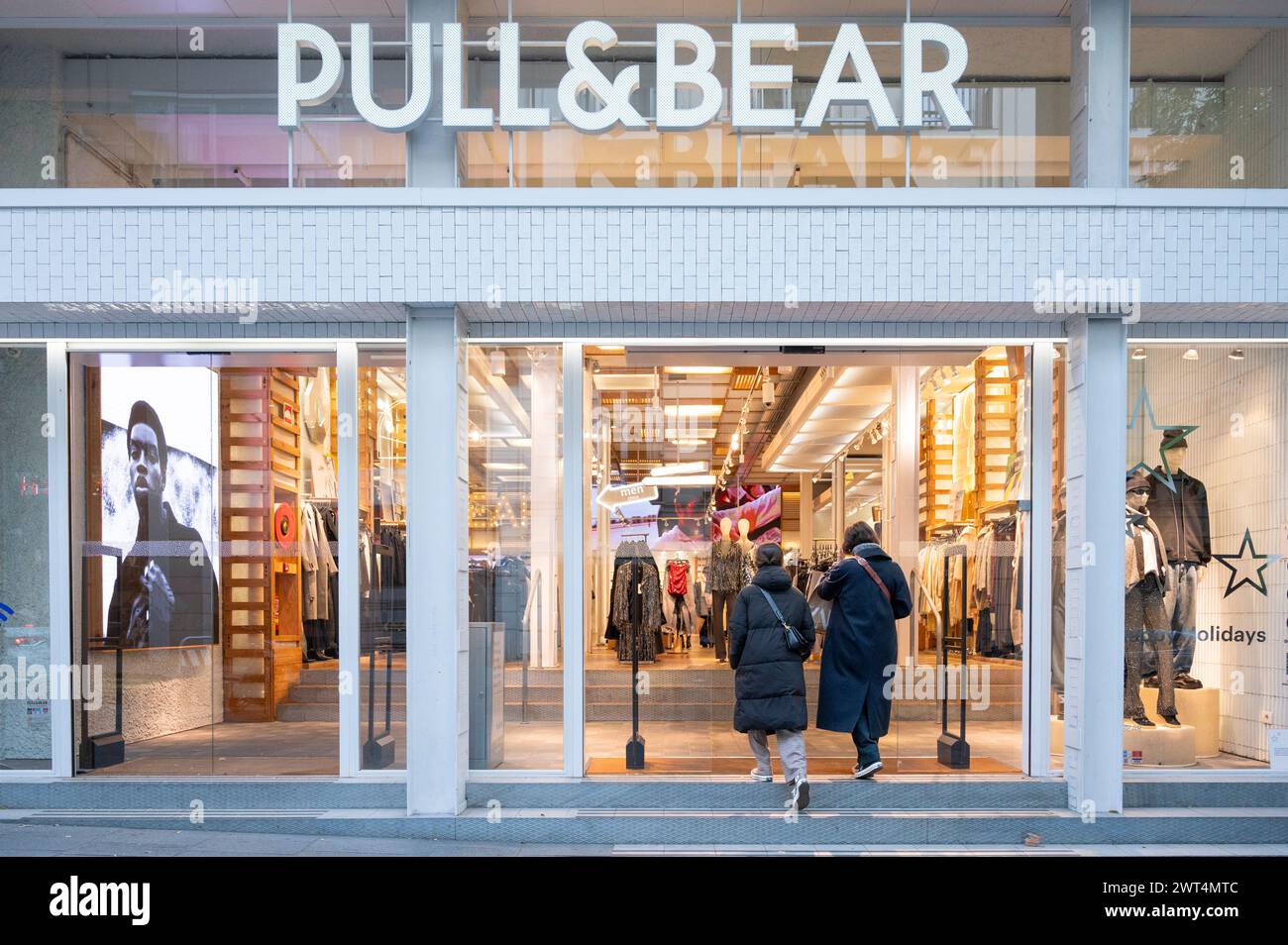 Customers enter the Spanish multinational clothing design retail company by Inditex, Pull & Bear ...