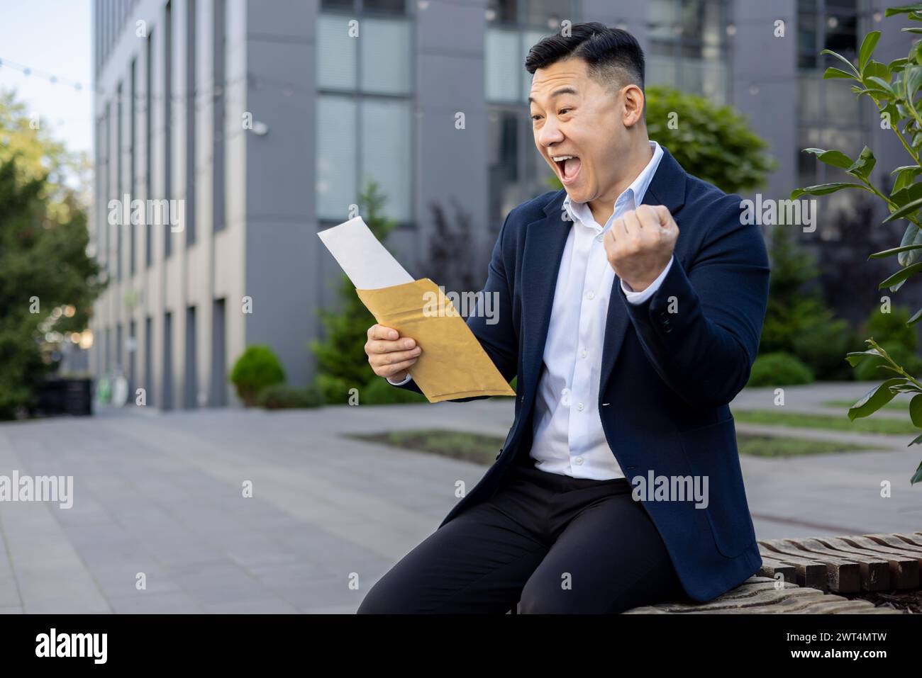 Joyous man in business attire receiving great news from a letter ...