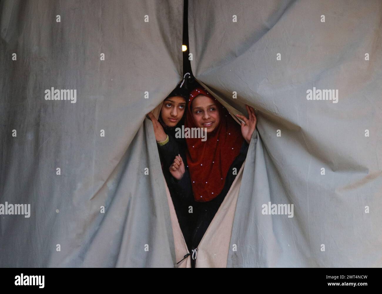 Srinagar, India. 15th Mar, 2024. March 15, 2024, Srinagar, India : Children looks out behind a ...