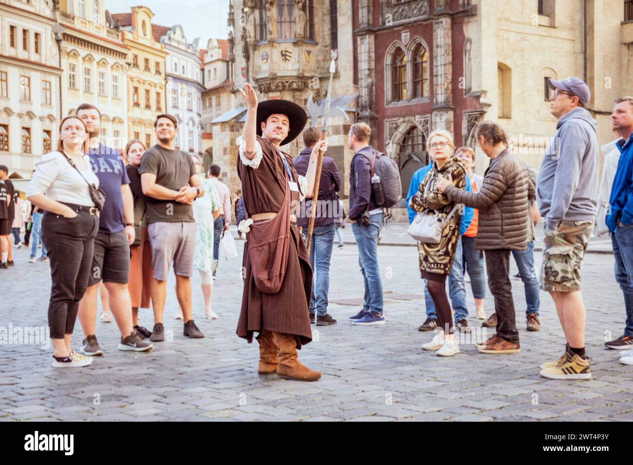 Storyteller in medieval attire engages audience in european cobblestone ...