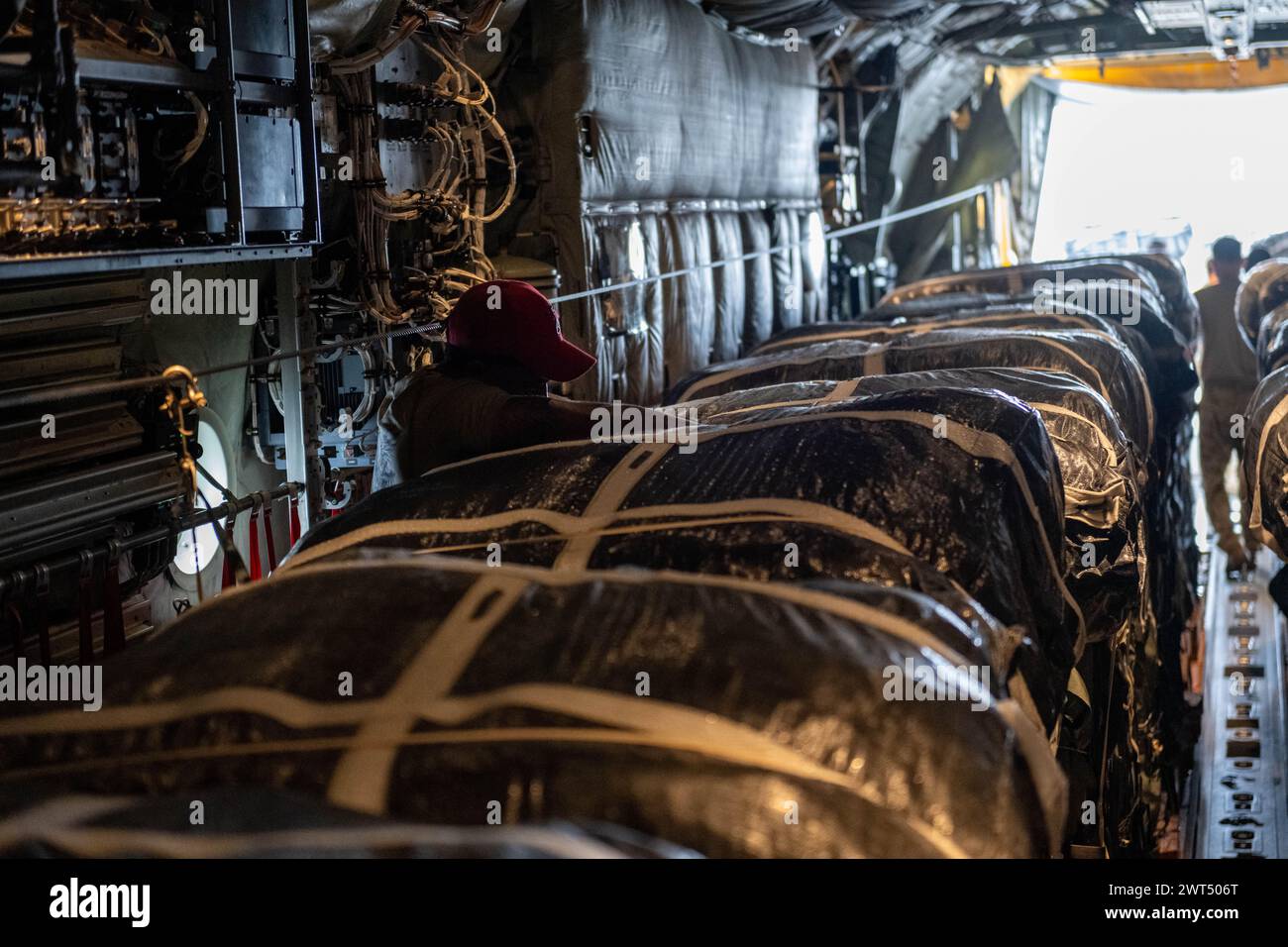 A U.S. Army rigger checks the parachute setup of humanitarian aid ...