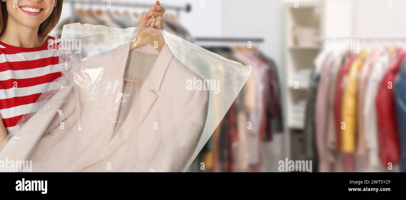 Dry-cleaning service. Woman holding hanger with jacket in plastic bag ...