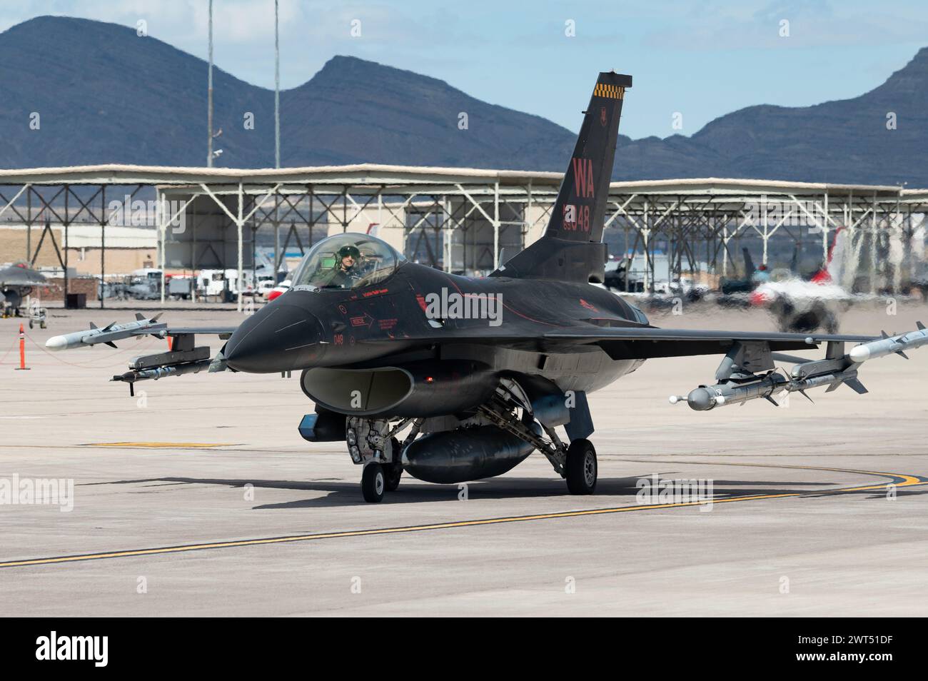 An F-16 Aggressor assigned to the 64th Aggressor Squadron, taxis to ...
