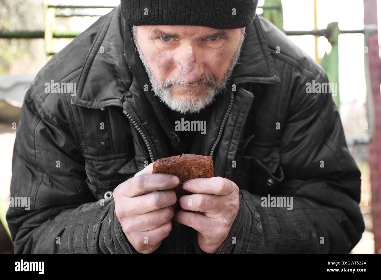 Poor homeless man holding piece of bread outdoors Stock Photo - Alamy
