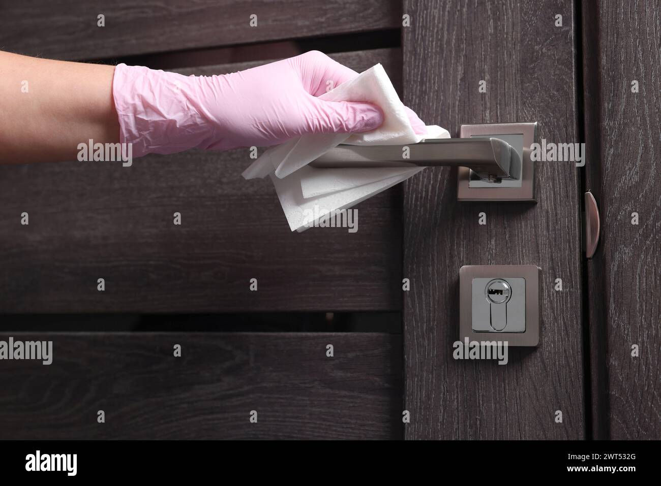 Woman wiping door handle with paper towel, closeup Stock Photo - Alamy