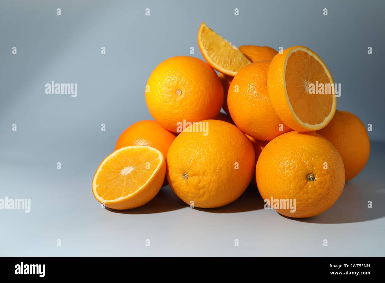 Many whole and cut oranges on grey background Stock Photo - Alamy