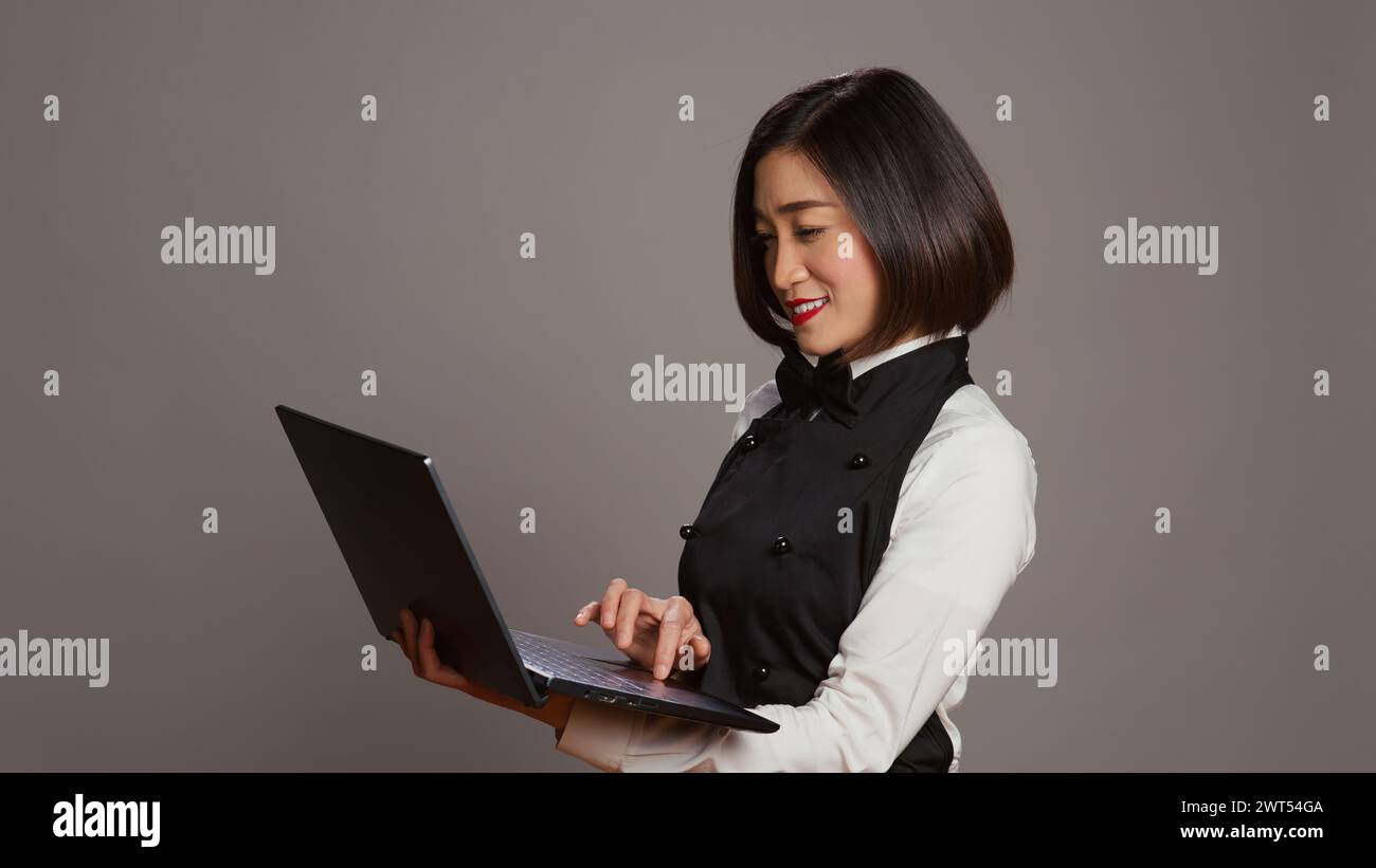 Smiling waitress serving meal checking hi-res stock photography and ...