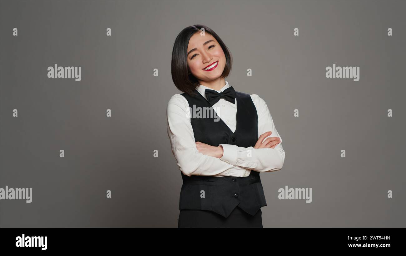 Asian receptionist posing with arms crossed on camera, feeling ...