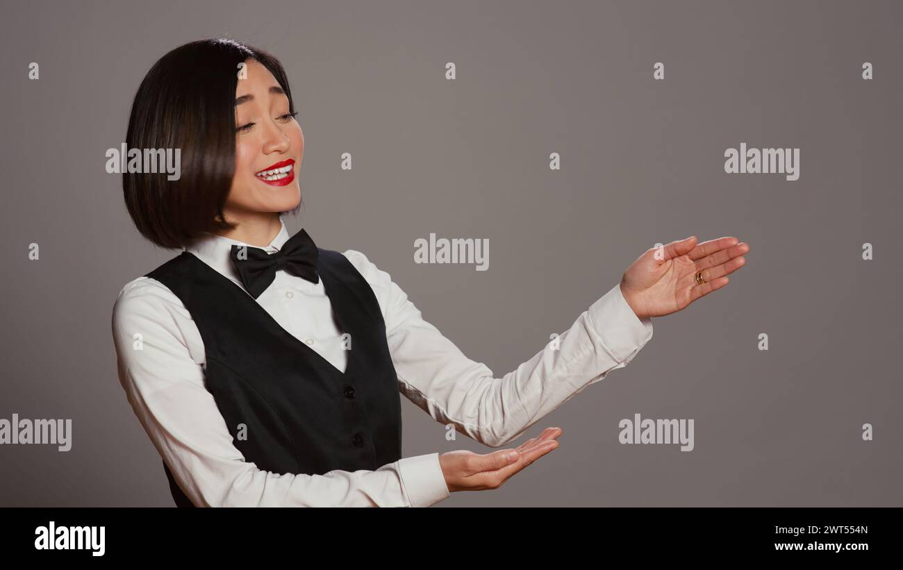 Reception staff doing web advertisement over grey background, pointing ...