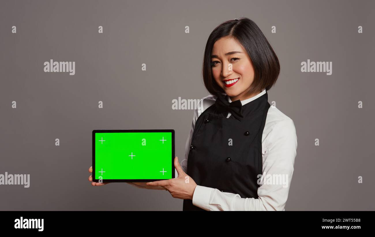 Woman waitress holding tablet with greenscreen display on camera ...