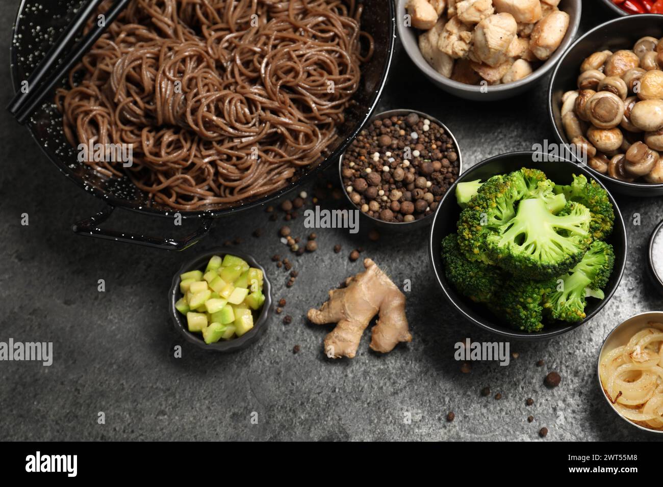Wok with noodles, chicken and other products on grey table, above view ...