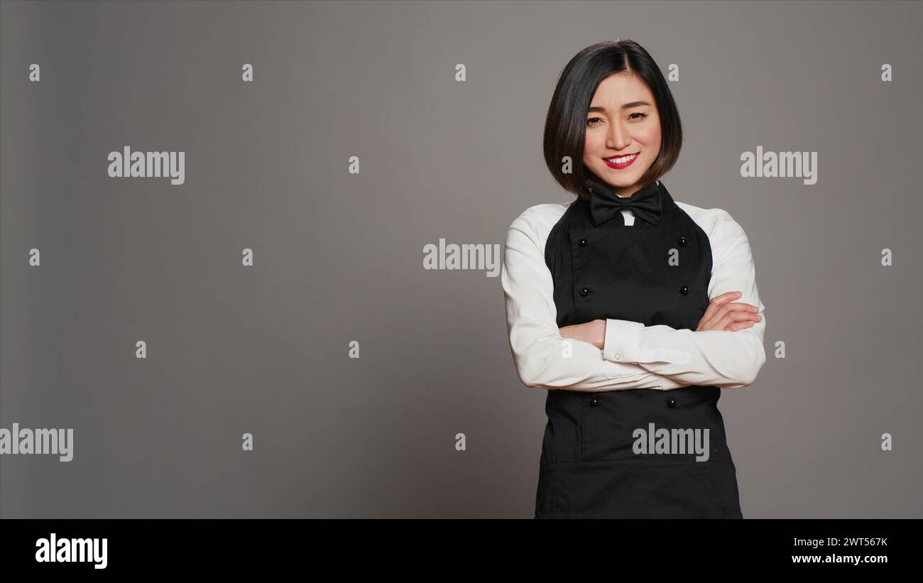 Asian diner employee prepared to serve food at tables, working in ...