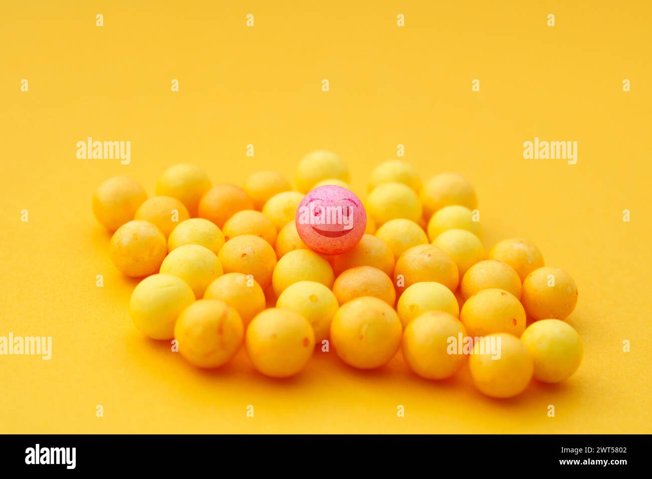 Happy pink sphere on top of expressionless yellow one Stock Photo - Alamy