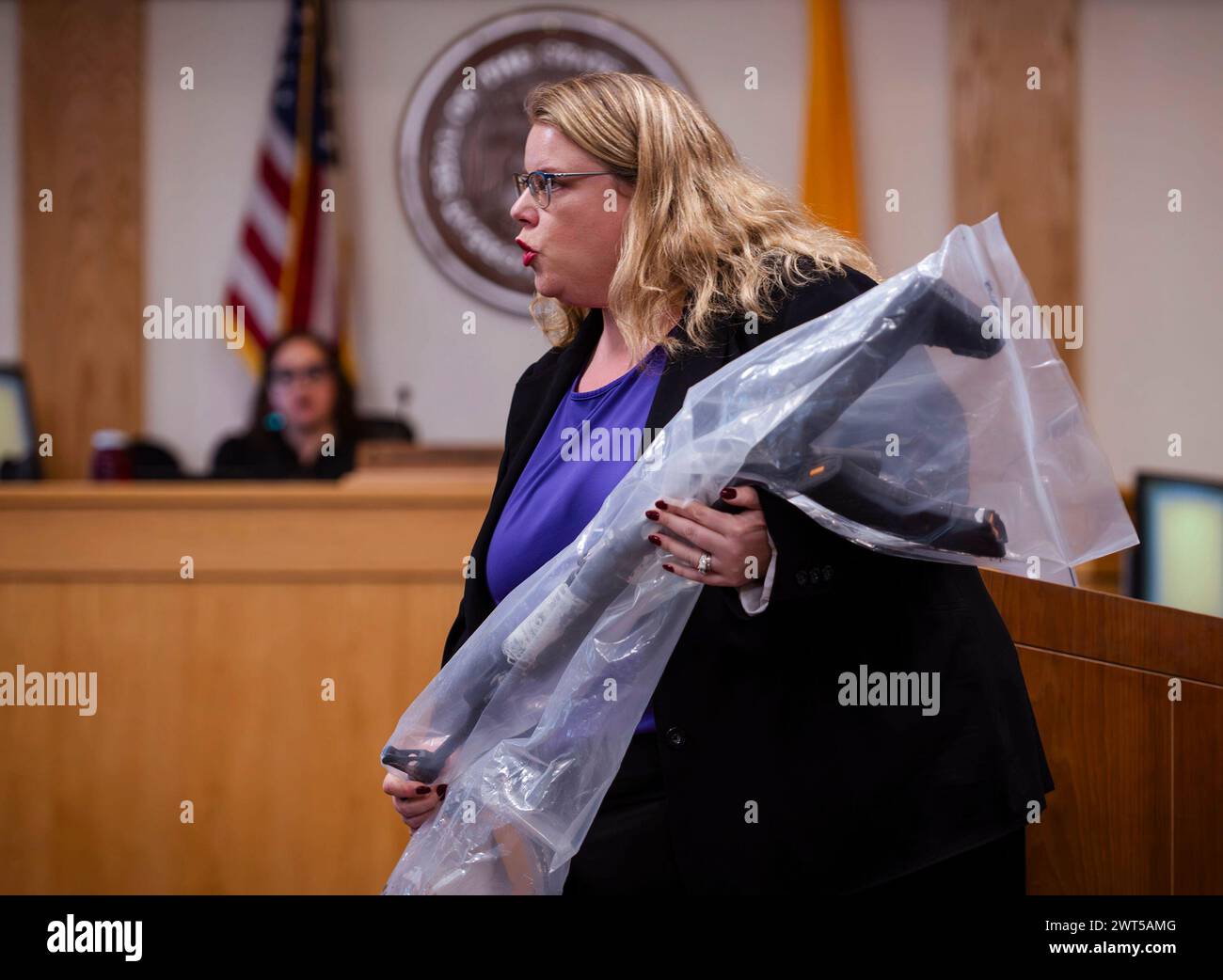 Defense attorney Megan Mitsunaga holds a AK-47 wrapped in plastic that ...