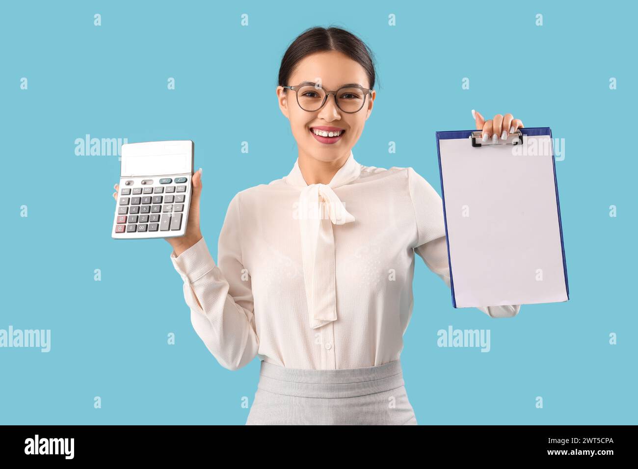Female Asian accountant with calculator and clipboard on blue ...