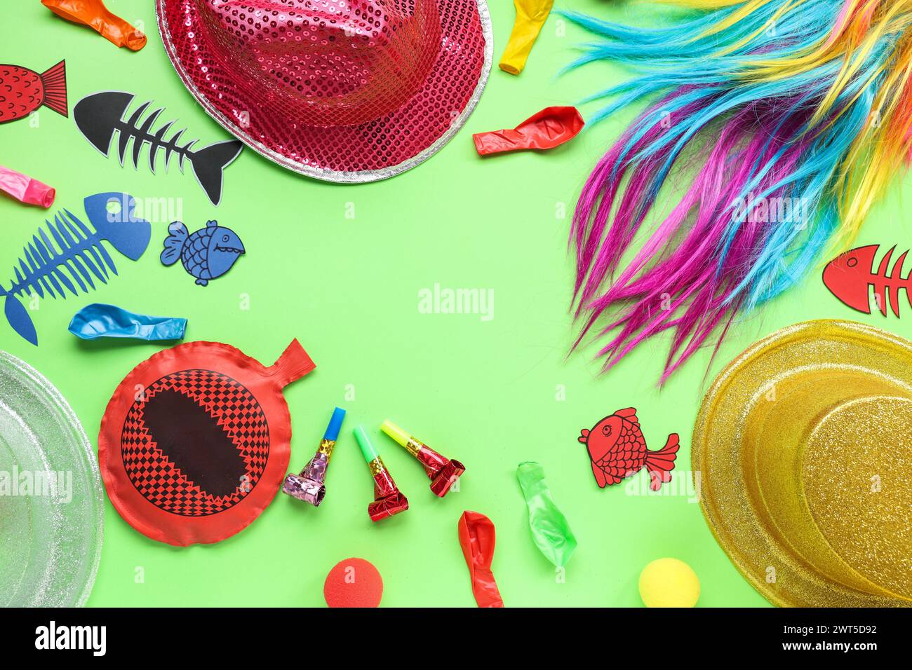 Frame made of wig, hats and party decor on green background. April ...