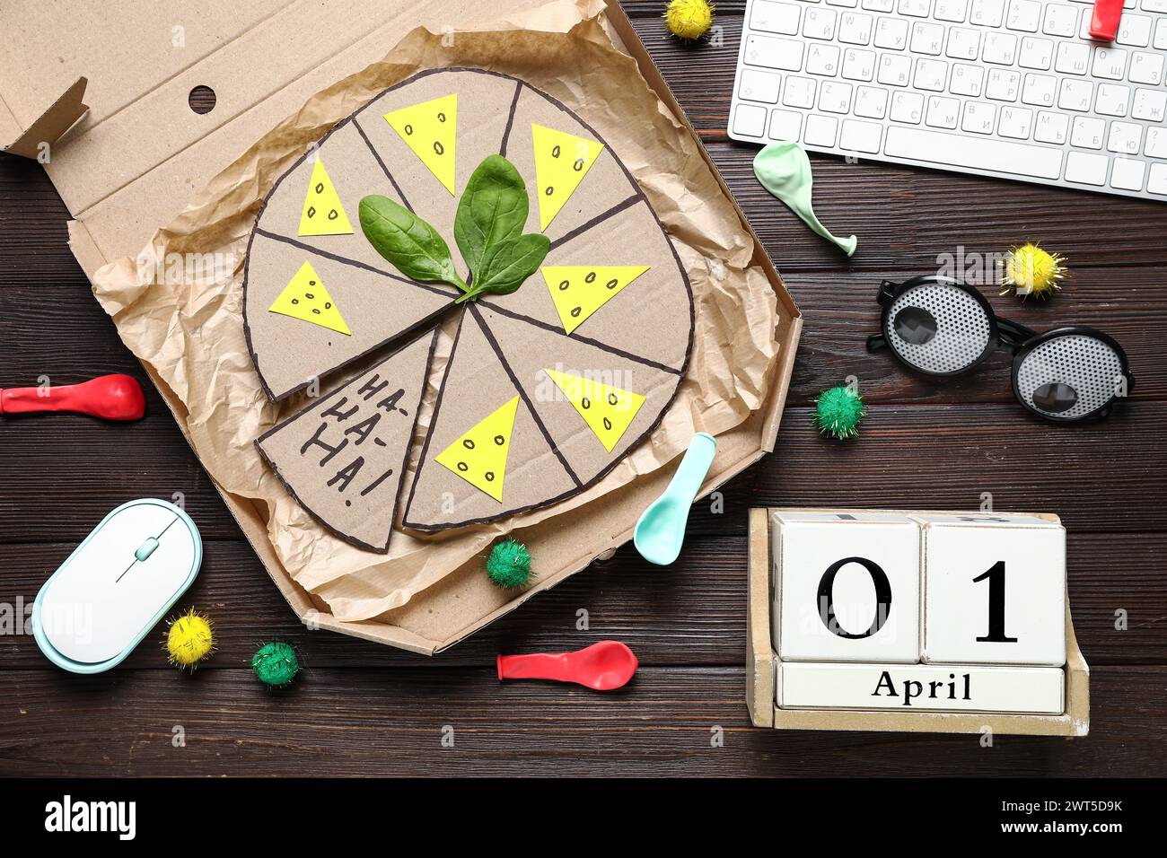 Carton pizza, funny glasses, computer keyboard and calendar on wooden ...
