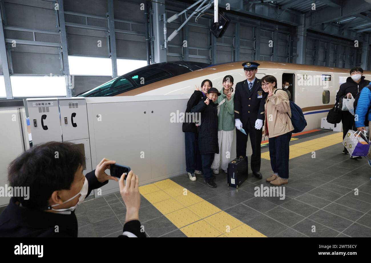 Passengers take a photo in front of Hokuriku Shinkansen at Tsuruga ...