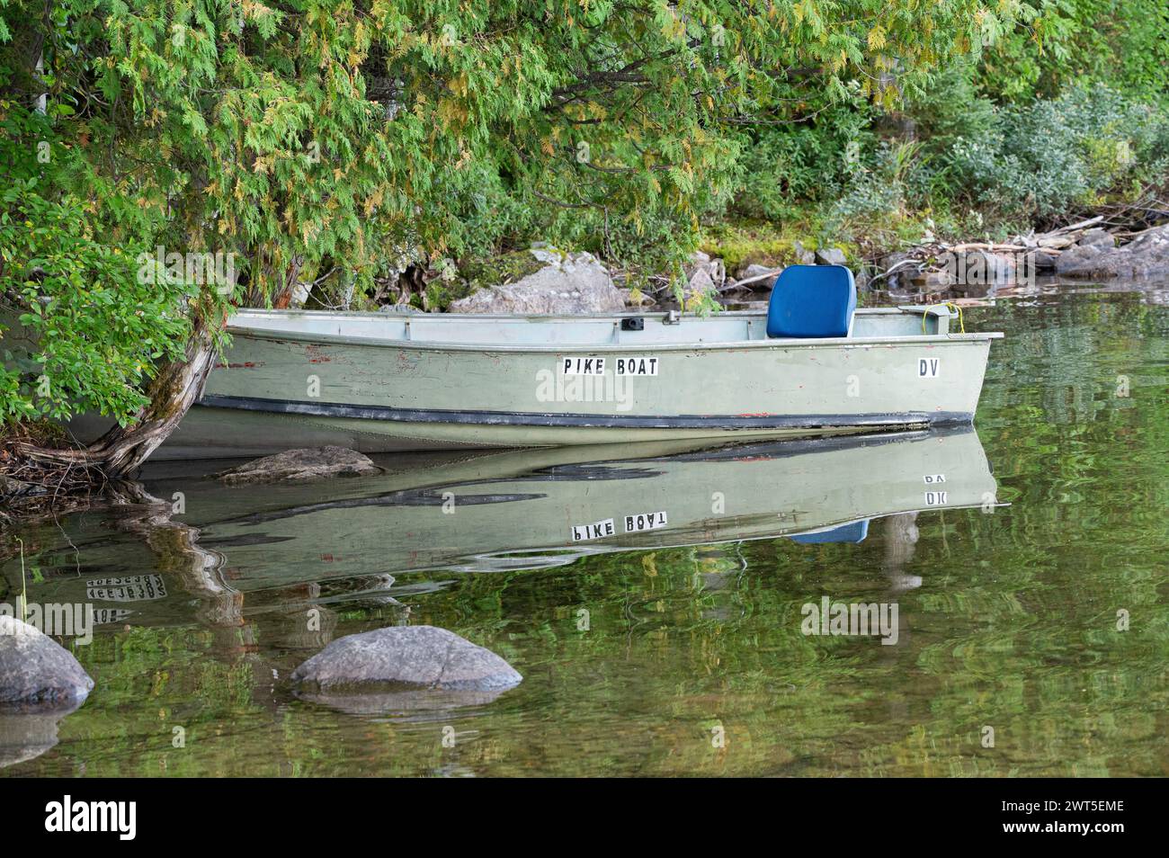 Old Steel Boat with no motor on the Shoreline of a calm lake Stock ...