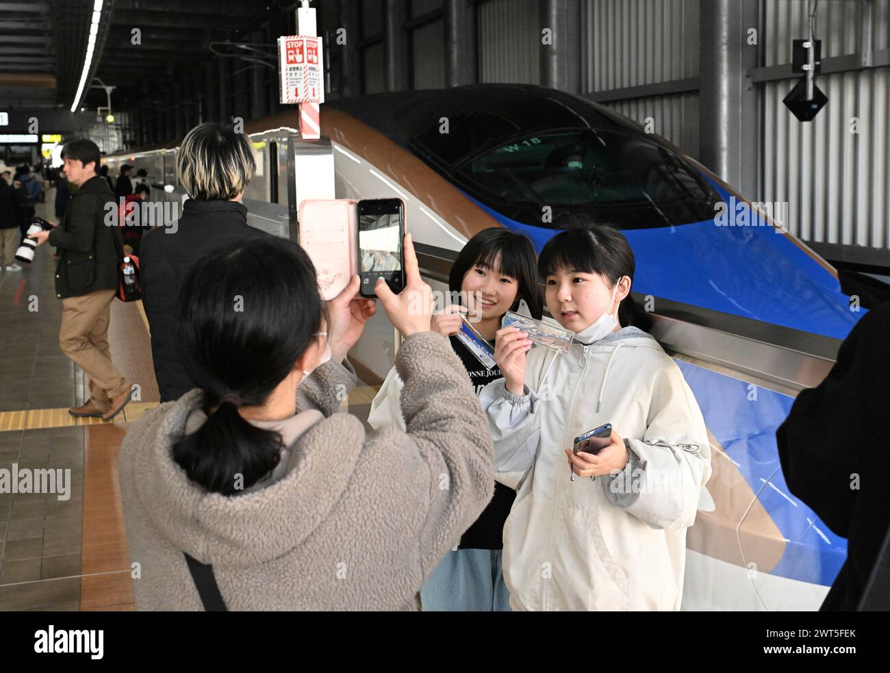 Passengers take a photo in front of Hokuriku Shinkansen at Tsuruga ...
