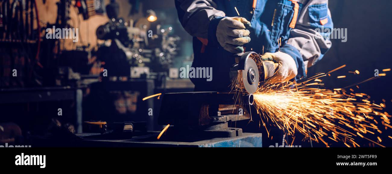 Locksmith in special clothes works in production. Metal processing with ...