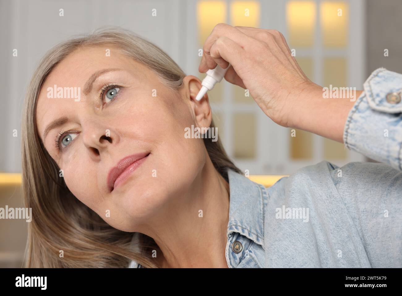 Woman applying medical ear drops at home Stock Photo - Alamy