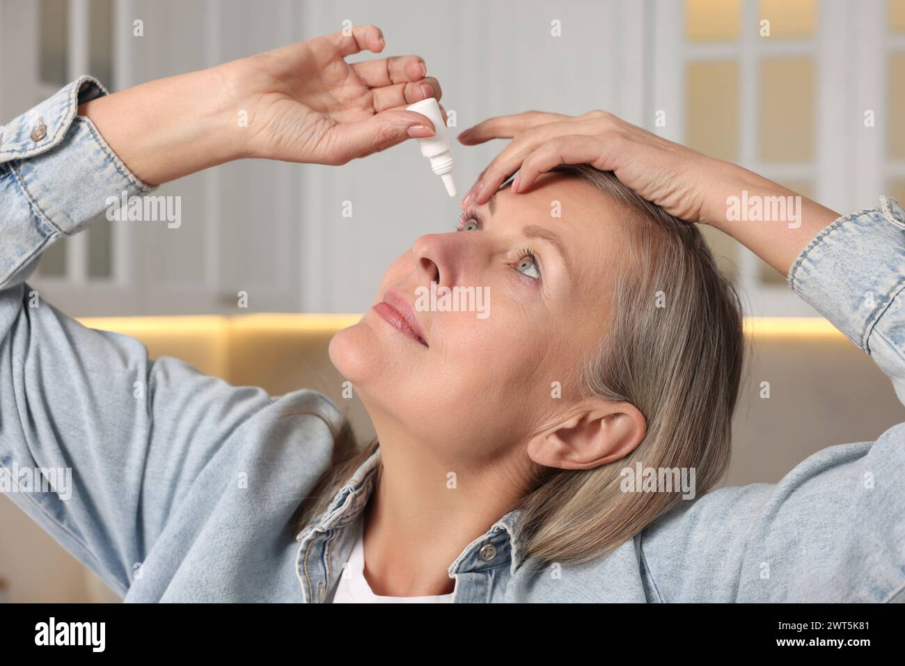 Woman applying medical eye drops at home Stock Photo - Alamy
