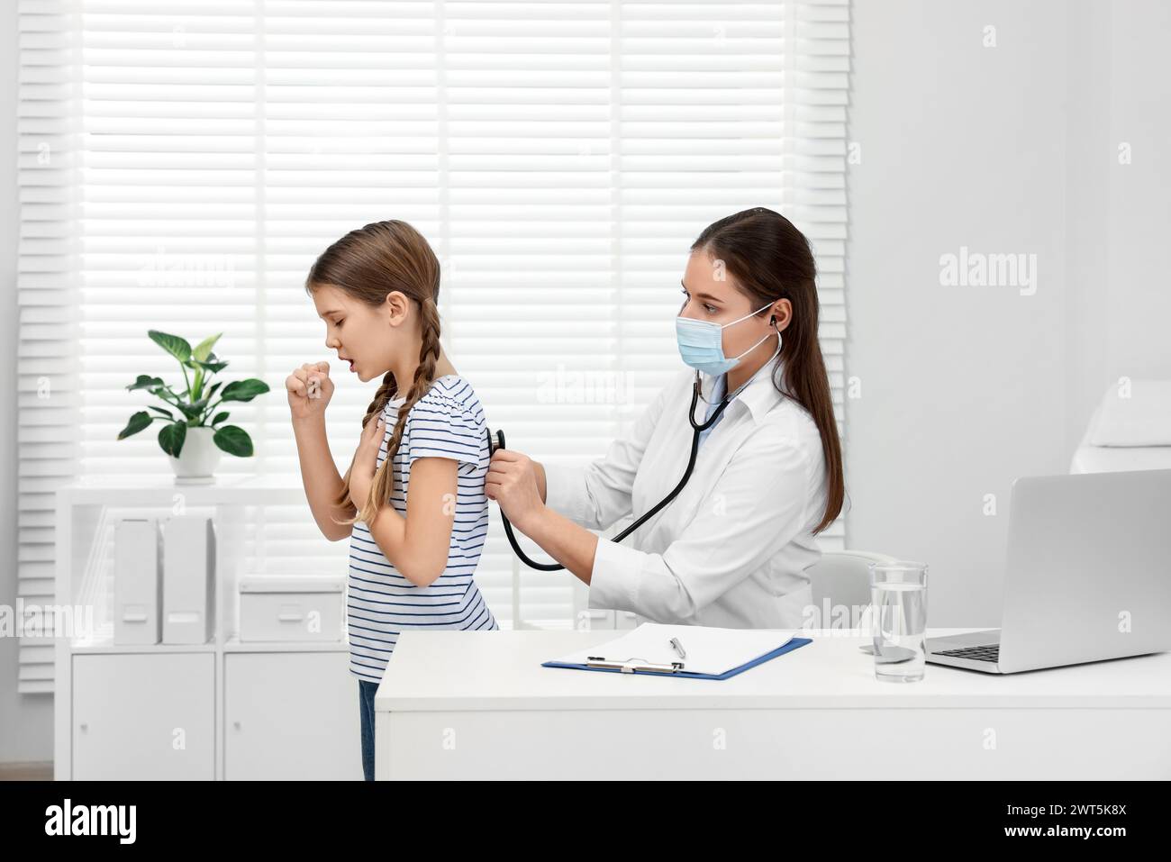 Doctor examining coughing girl in hospital. Cold symptoms Stock Photo ...