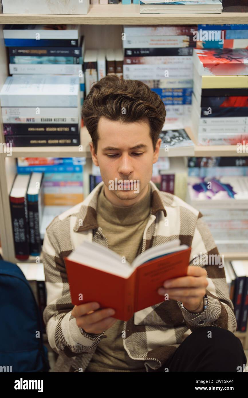 Young man reading book surrounded hi-res stock photography and images ...