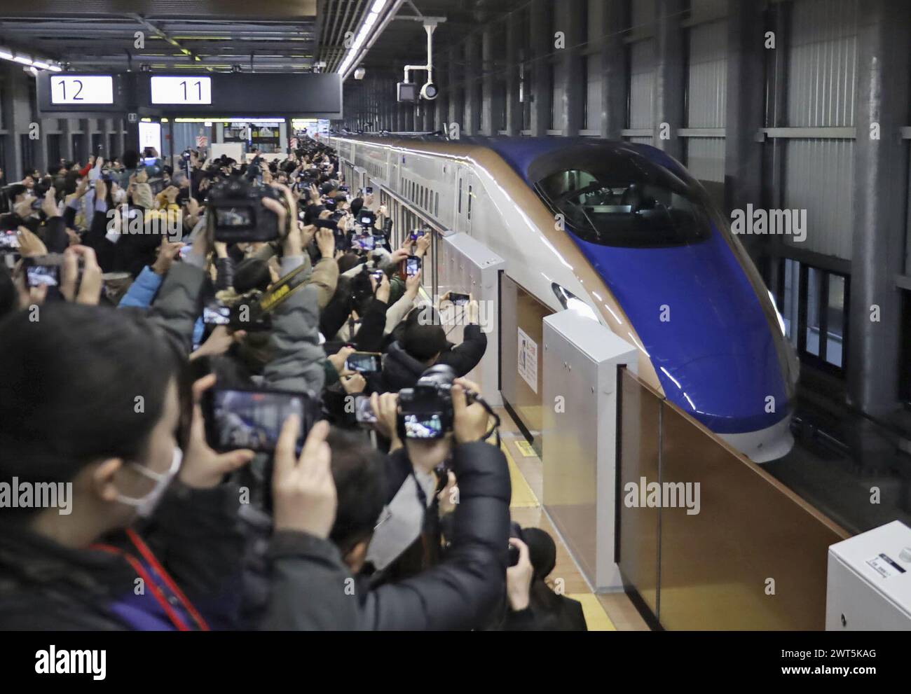 People celebrate the arrival of the first train bound for Tokyo at JR Fukui Station in Fukui ...