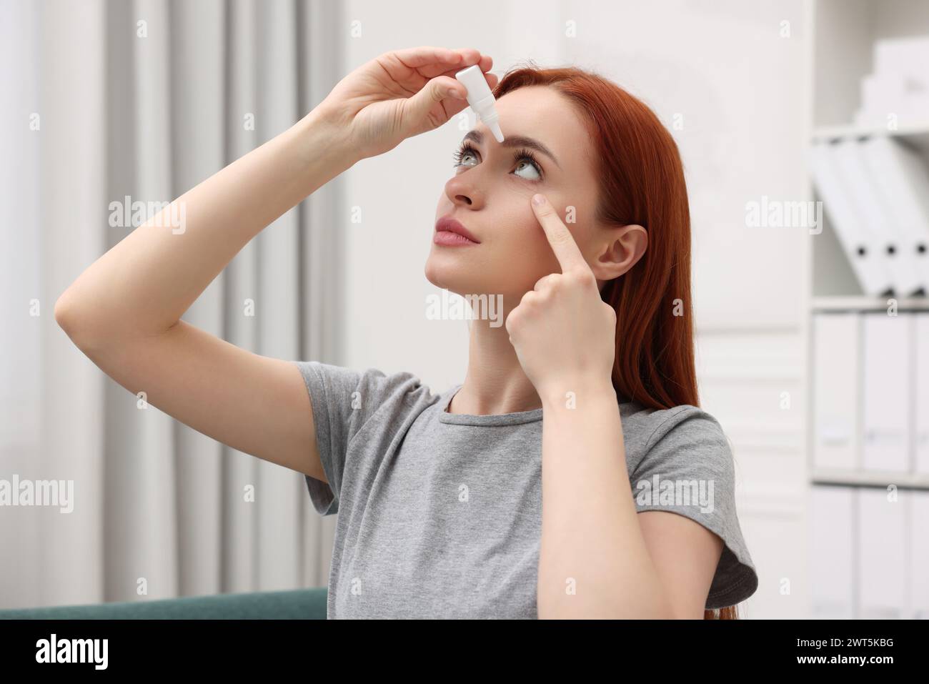 Woman applying medical eye drops at home Stock Photo - Alamy