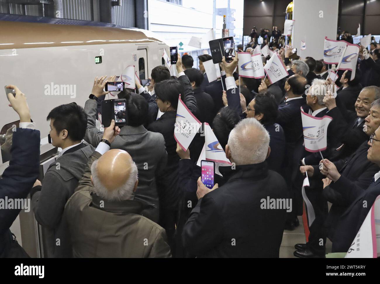 People celebrate the arrival of the first train bound for Tokyo at JR Fukui Station in Fukui ...