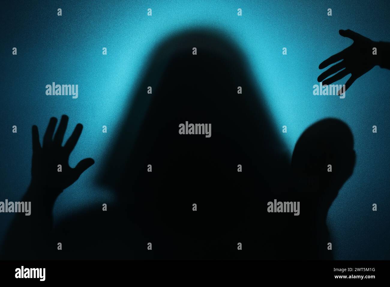 Silhouette of ghosts behind glass against blue background Stock Photo ...