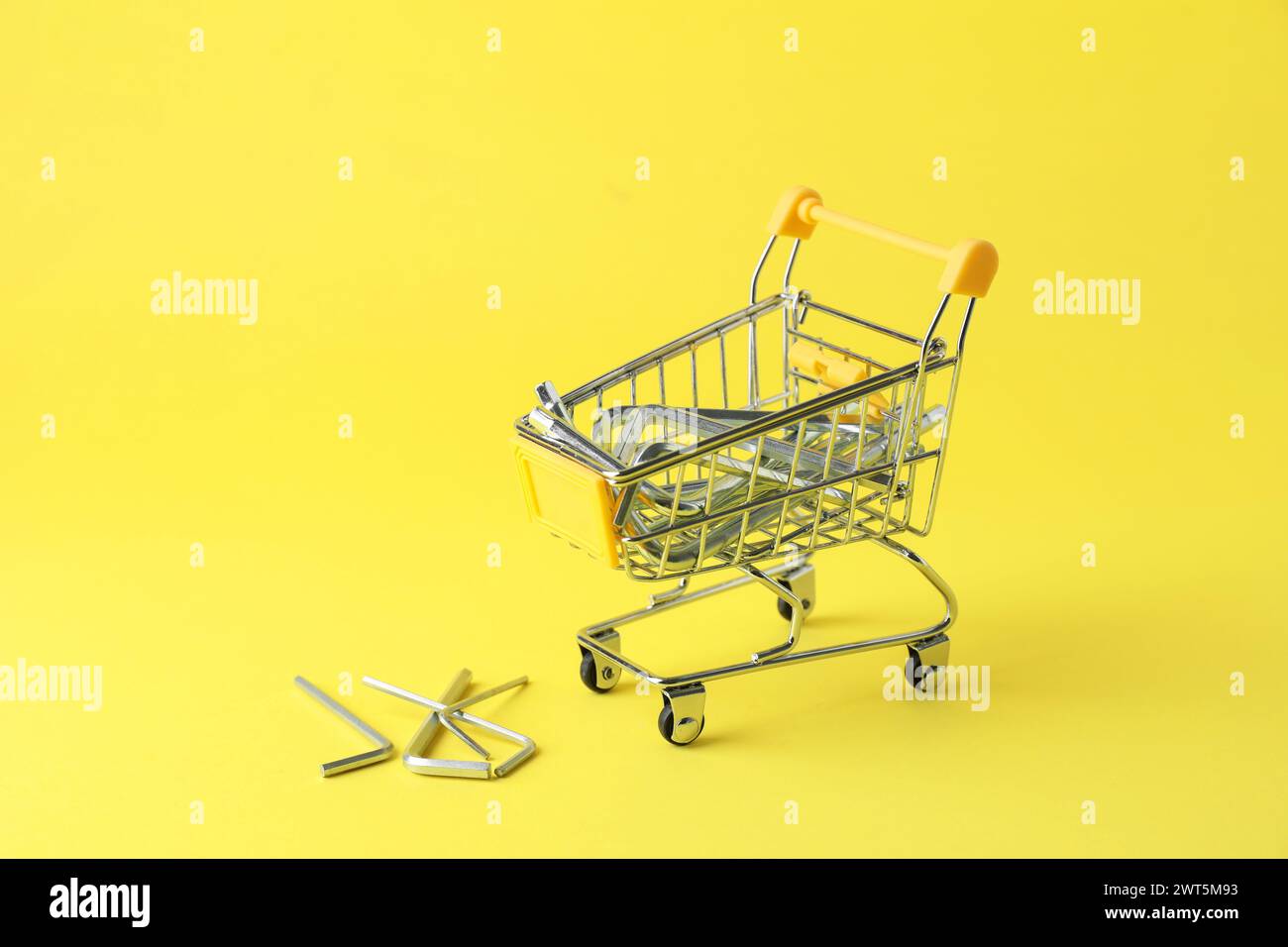 Small shopping cart with hexagon wrench set on yellow background ...