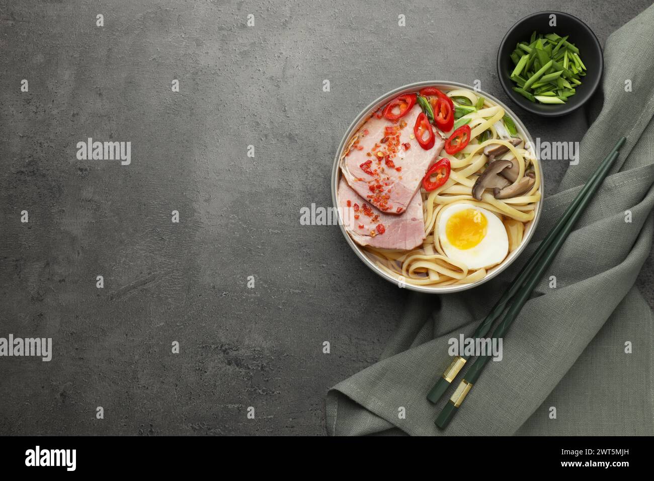 Delicious ramen in bowl served on grey textured table, flat lay and ...