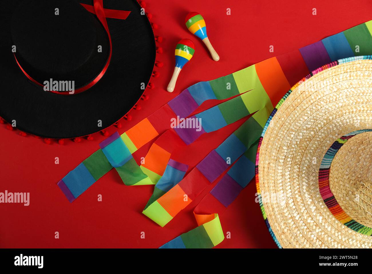Mexican sombrero and black Flamenco hats and maracas on red background ...