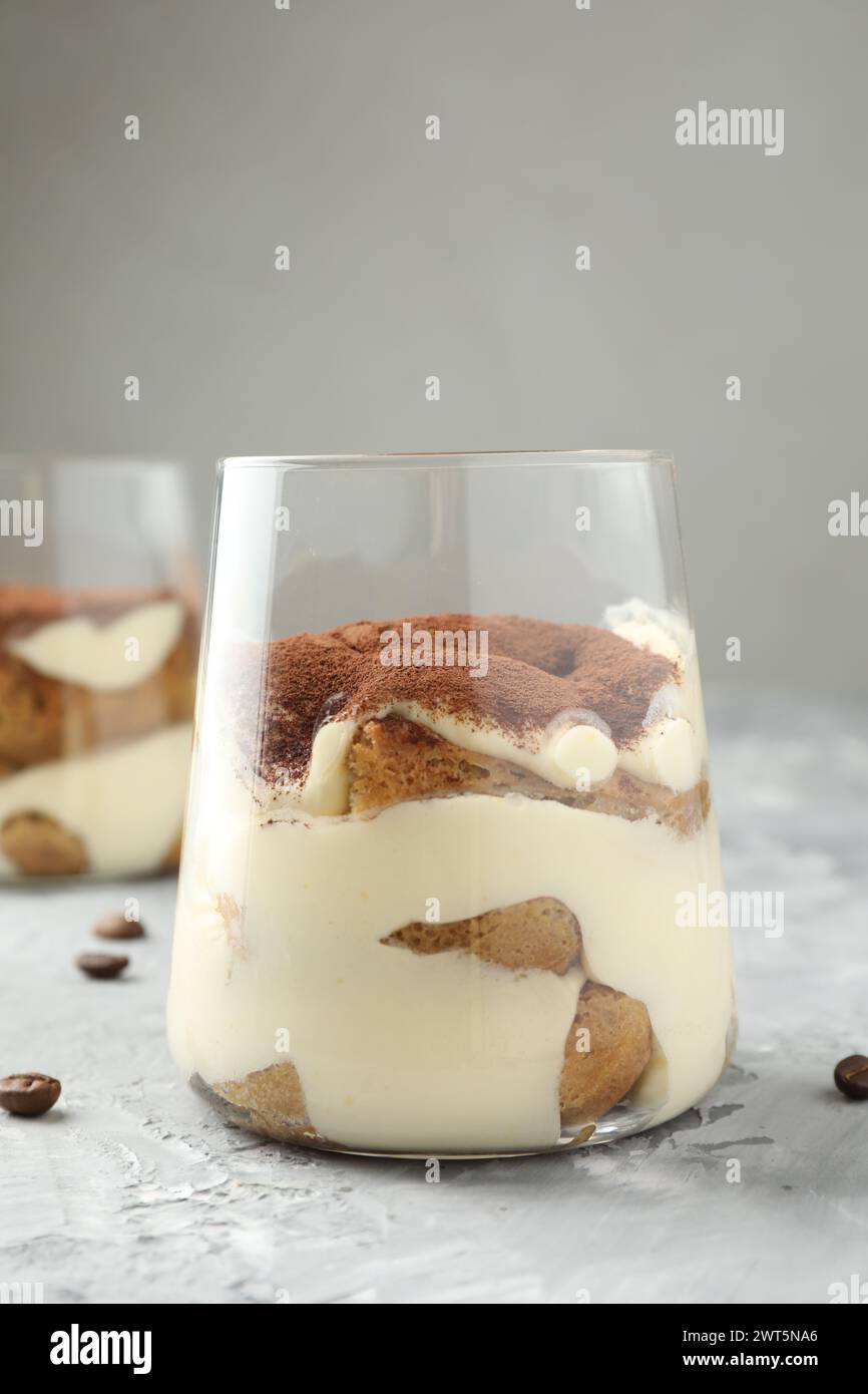 Delicious tiramisu in glass on grey textured table, closeup Stock Photo ...