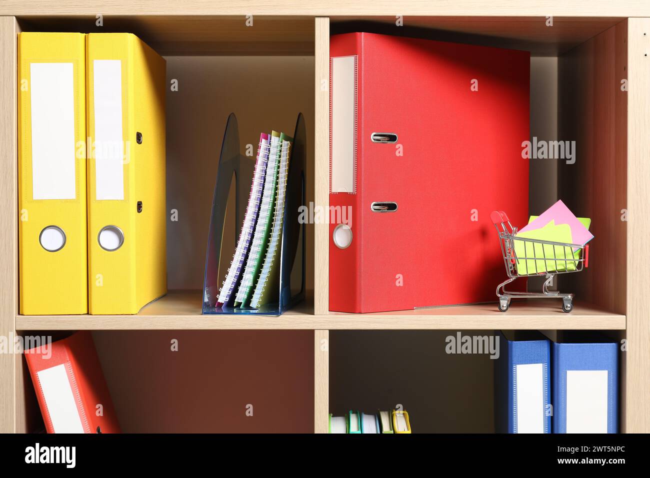 Colorful binder office folders and other stationery on shelving unit ...