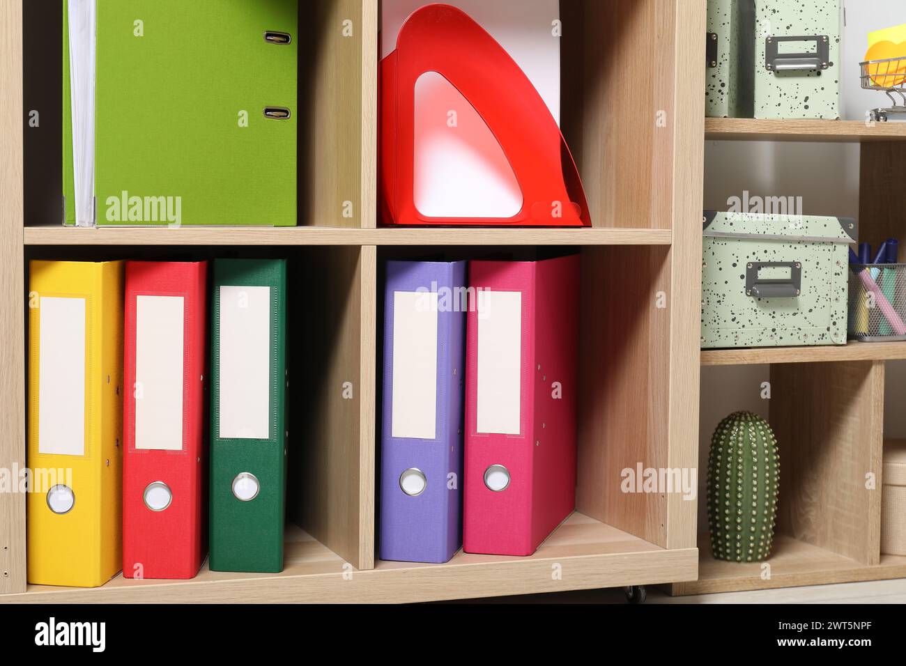Colorful binder office folders and other stationery on shelving unit ...