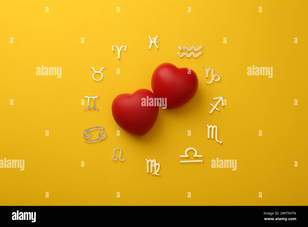 Zodiac signs and red hearts on yellow background, flat lay Stock Photo ...