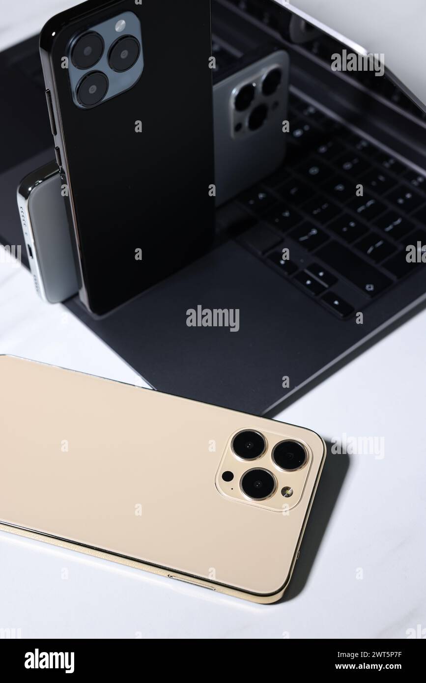 Modern laptop and smartphones on white table, closeup Stock Photo - Alamy