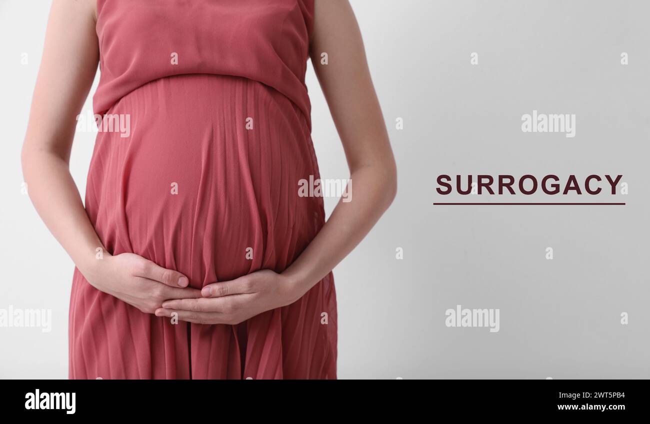 Surrogacy. Pregnant woman touching her belly on light background ...