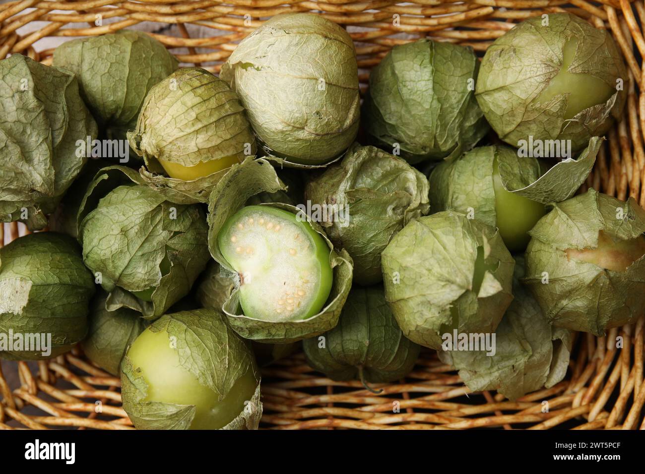 Fresh green tomatillos with husk in wicker basket, top view Stock Photo ...