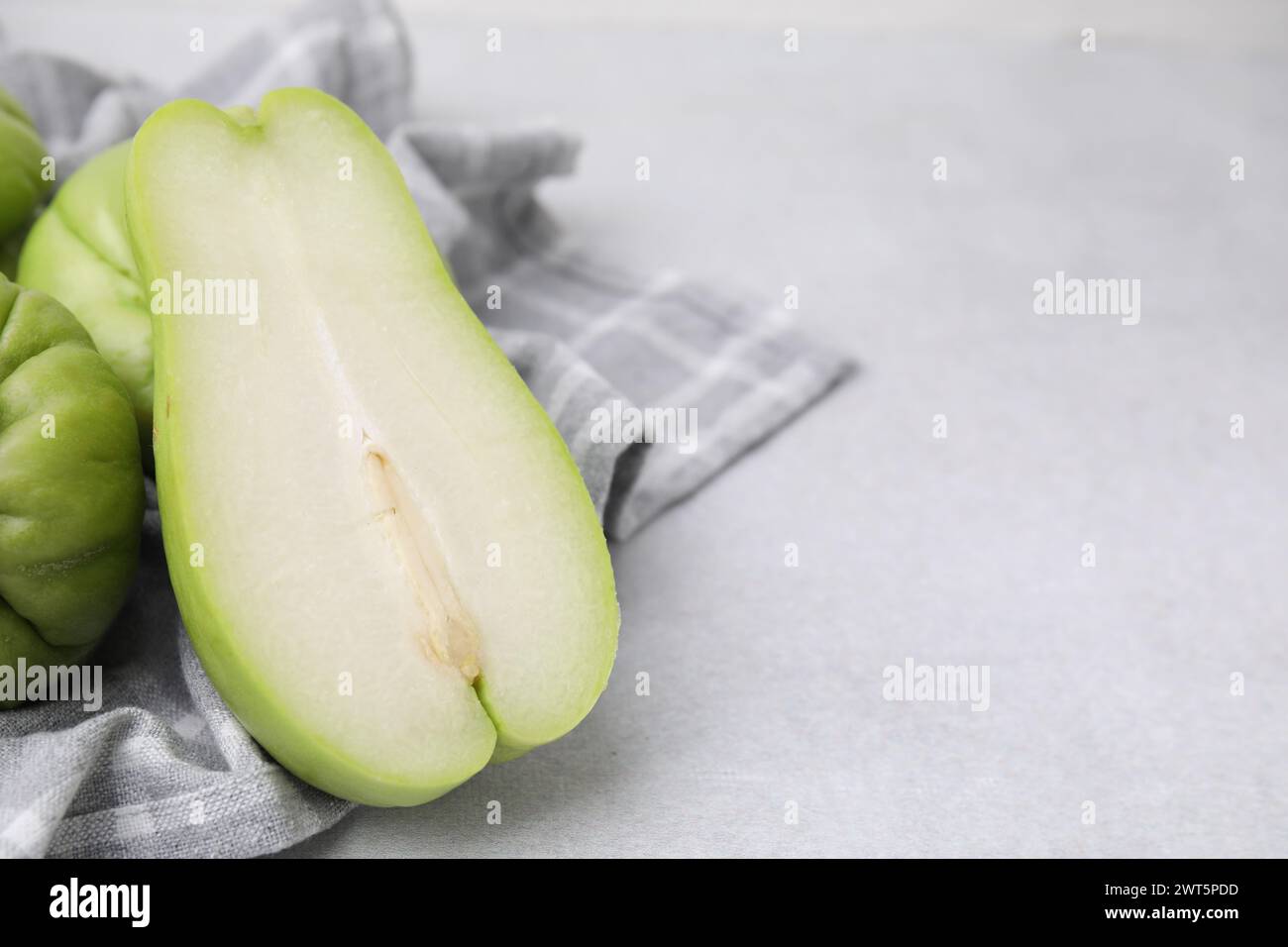 Cut and whole chayote on gray table, closeup. Space for text Stock ...