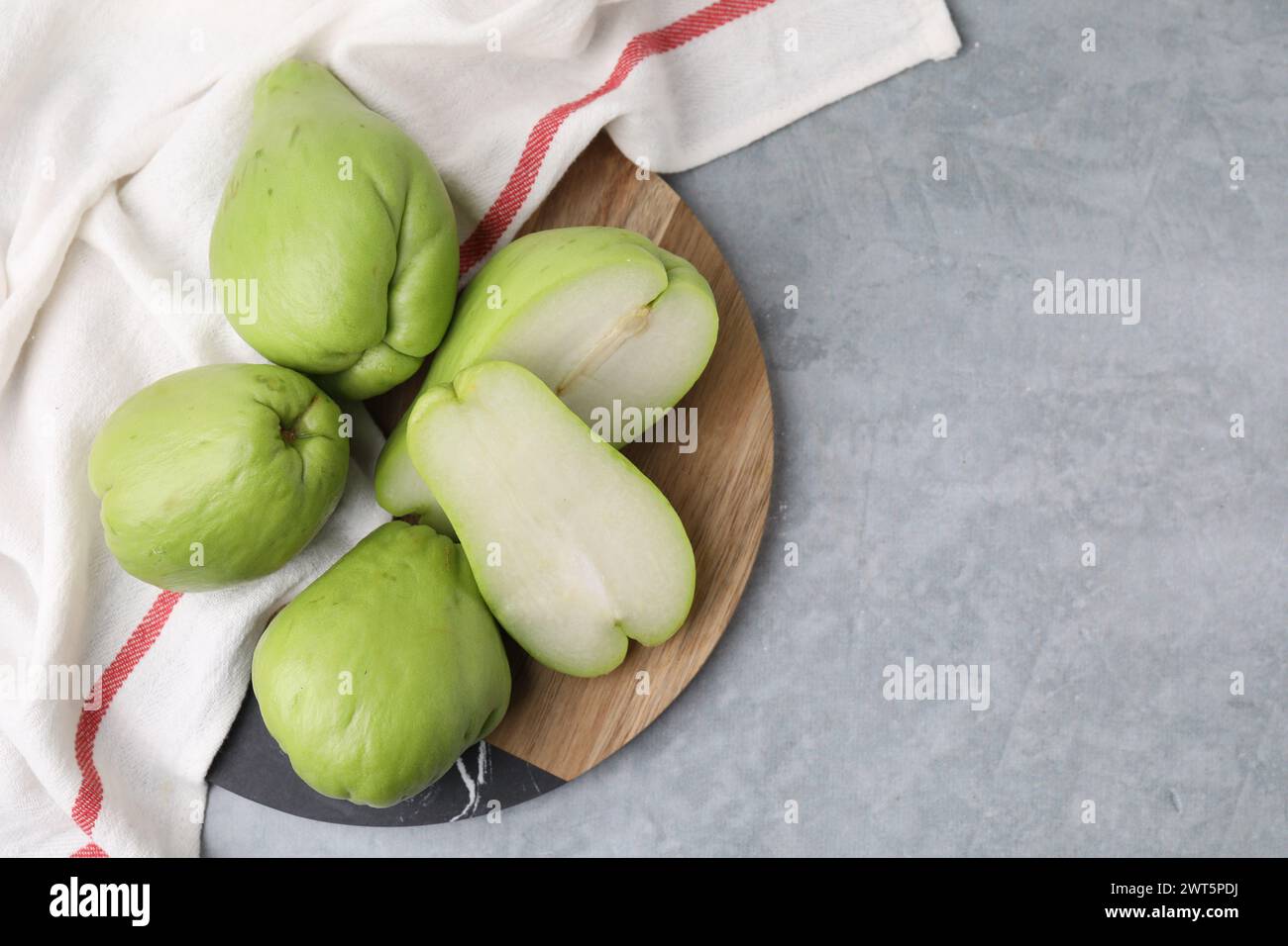 Cut and whole chayote on gray table, top view. Space for text Stock ...