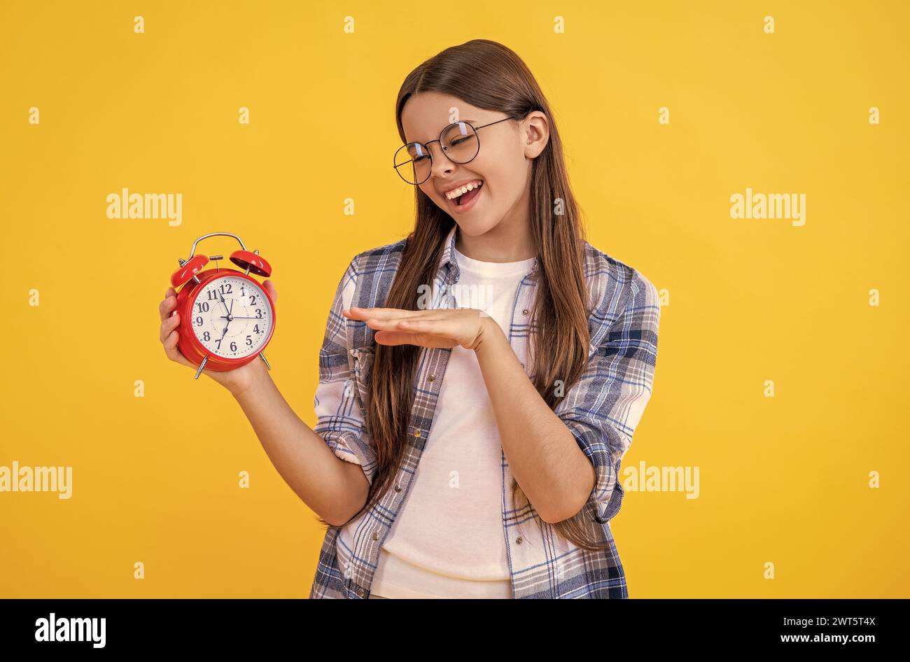 Teen girl hold alarm clock. school time. Teen girl checking the clock ...