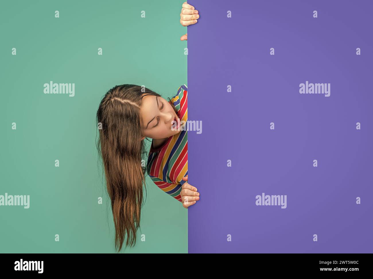 shocked kid behind blank blue paper with copy space for advertisement ...