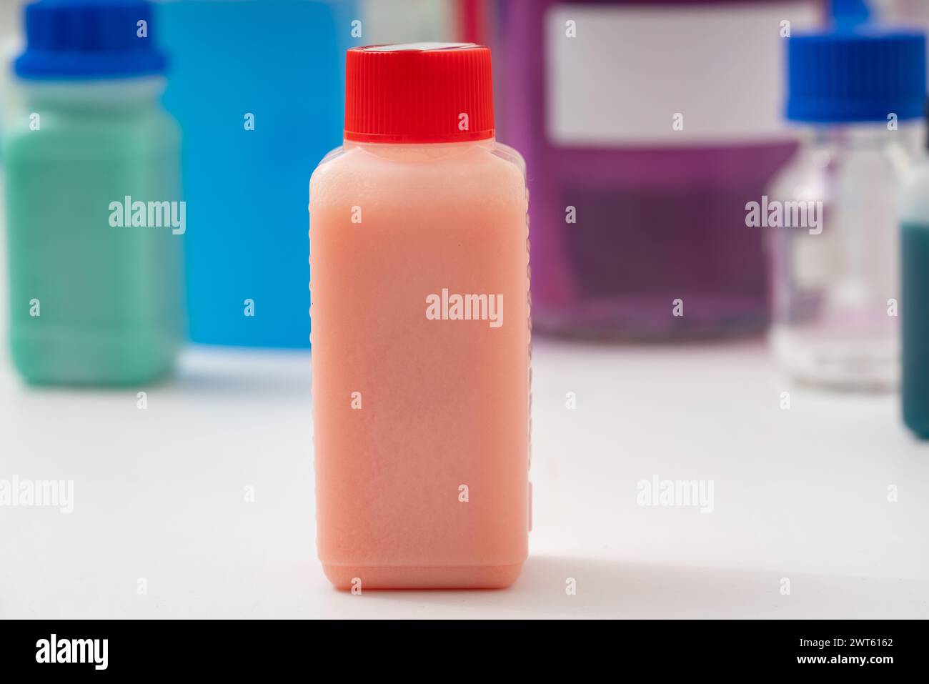 Plastic bottle with red liquid. Samples of food colouring in a food ...