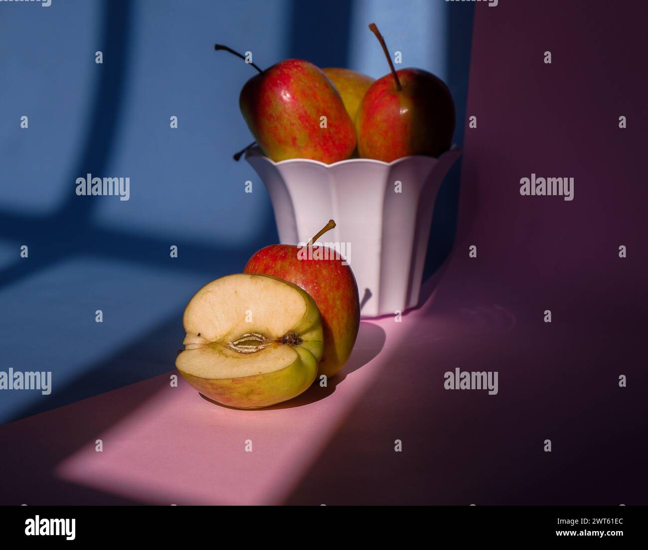Photo of an apple in a container on a pink and blue background Stock ...