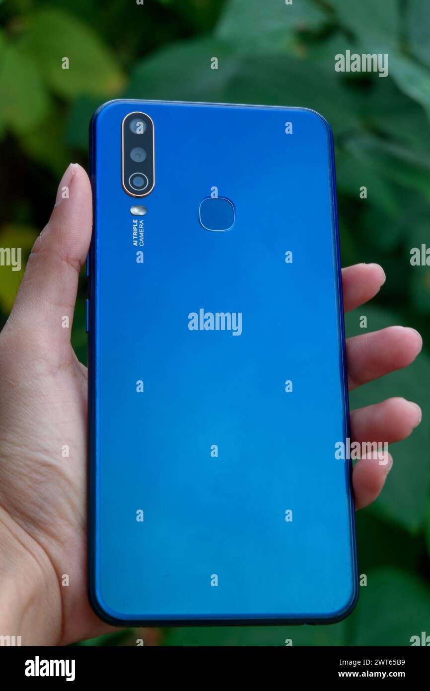 Photo of a small Asian child holding an aqua blue smartphone Stock ...